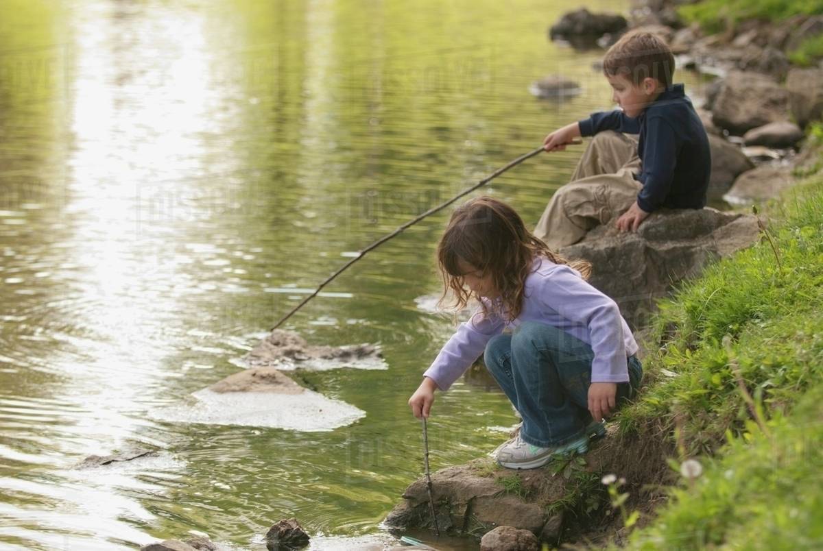 Two Kids Playing In A Pond - Royalty-free Stock Photo | Dissolve