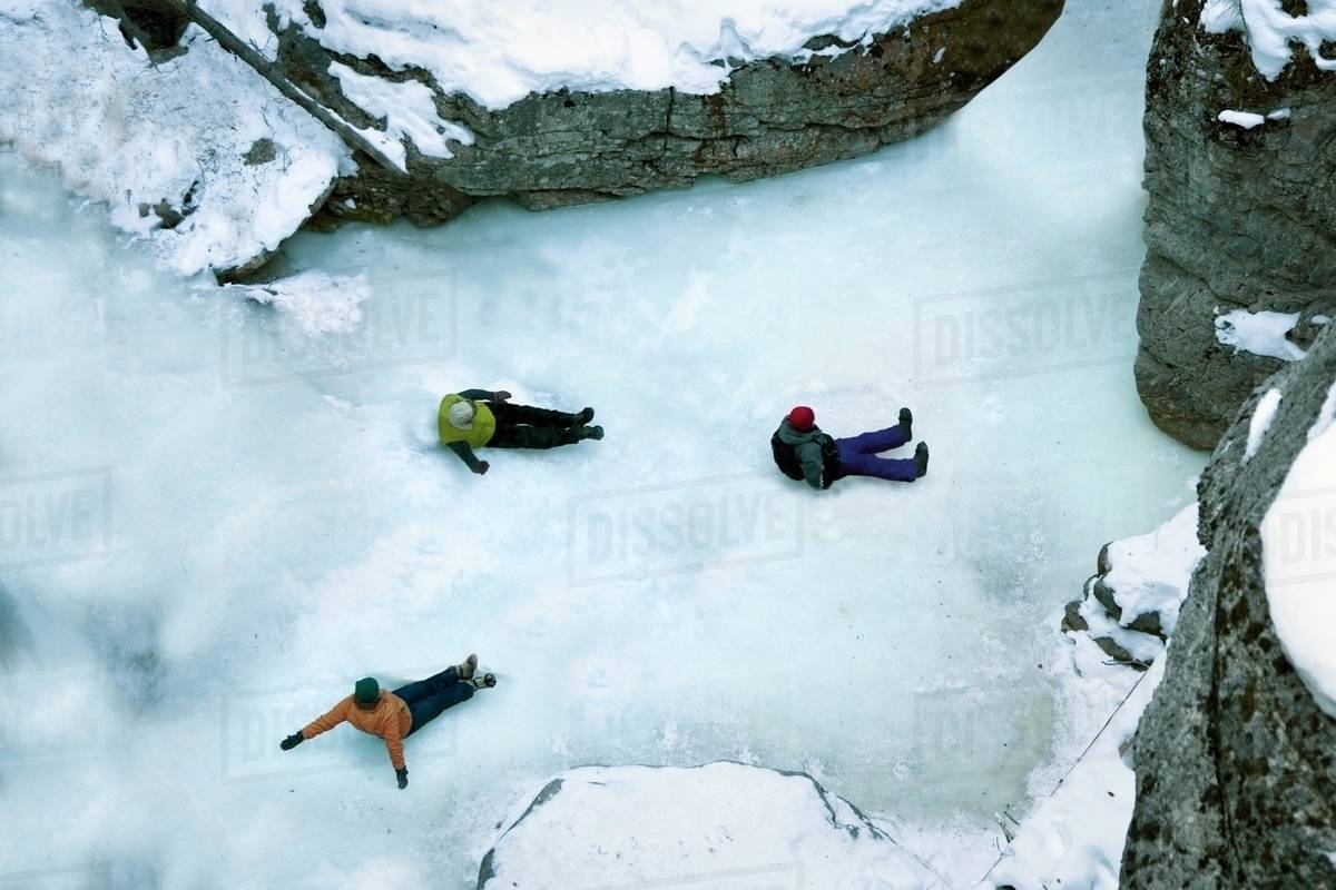 People Sliding Down Ice In Canyon - Royalty-free Stock Photo | Dissolve