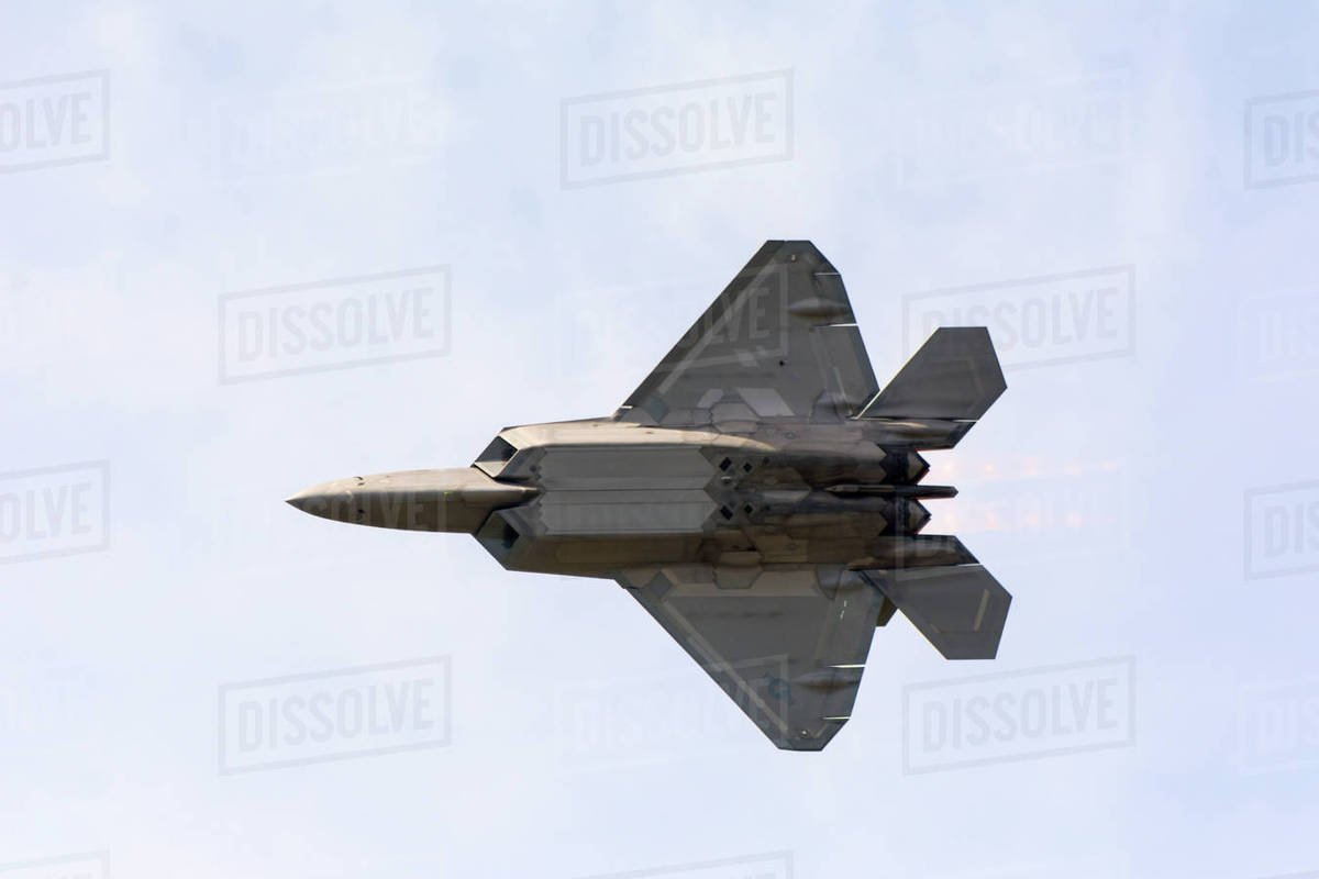 A stealth F 22 Raptor fighter jet in flight showing it's underside ...