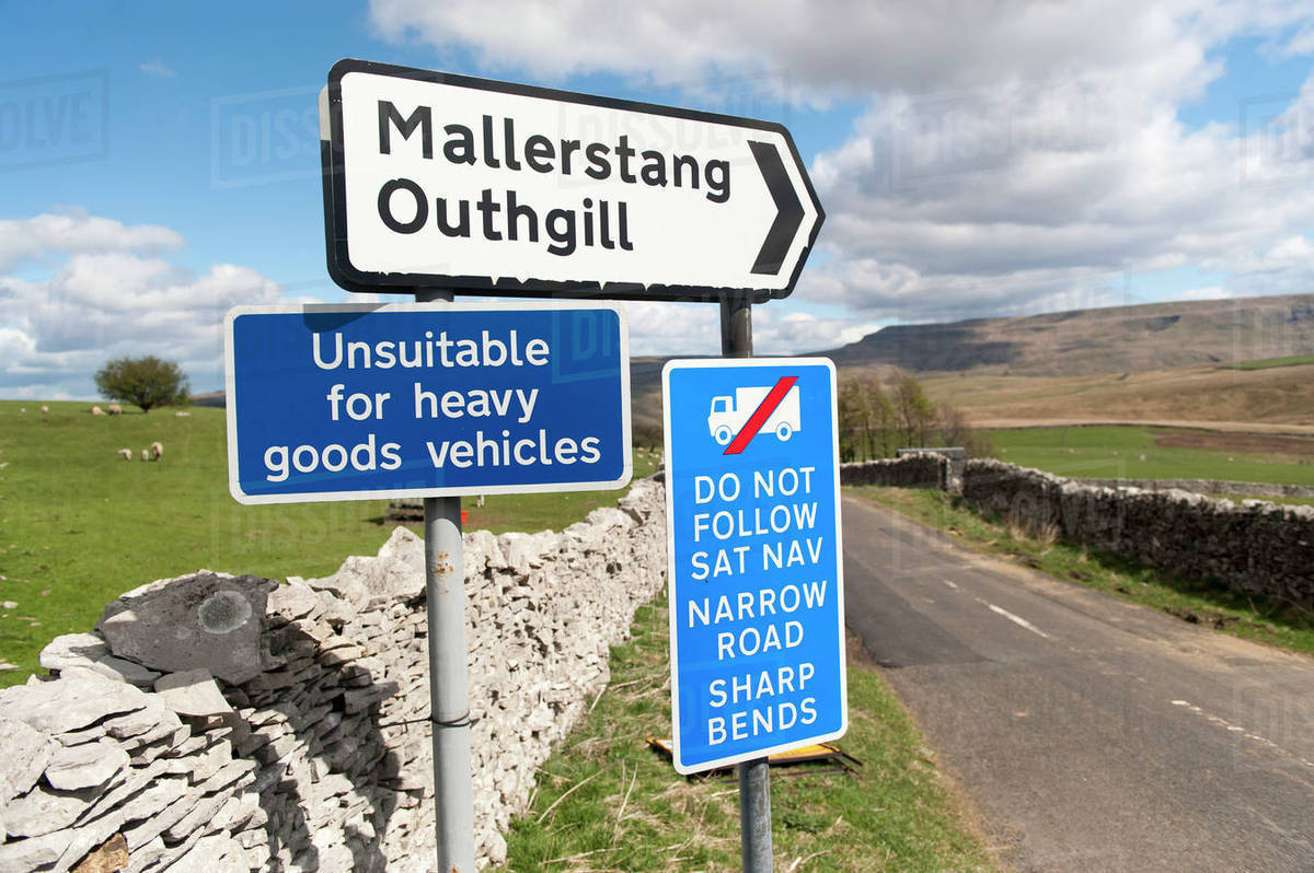Signs on a narrow road warning wagons against following their Sat-Nav ...