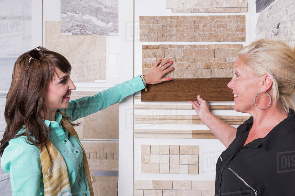 Design consultant and interior designer selecting tiles in showroom of ...
