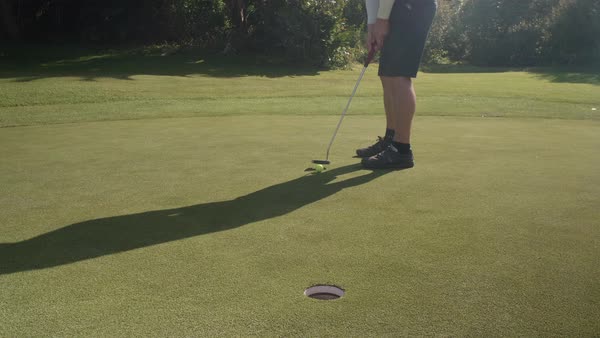 Man putting on green for birdie on golf course, healthy active sport ...