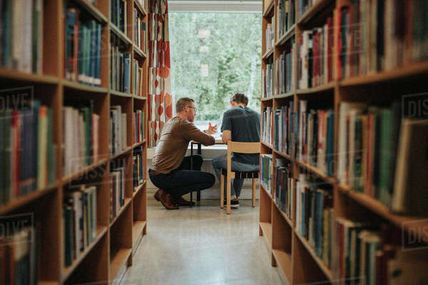 Professor explaining student in library at university - Royalty-free ...