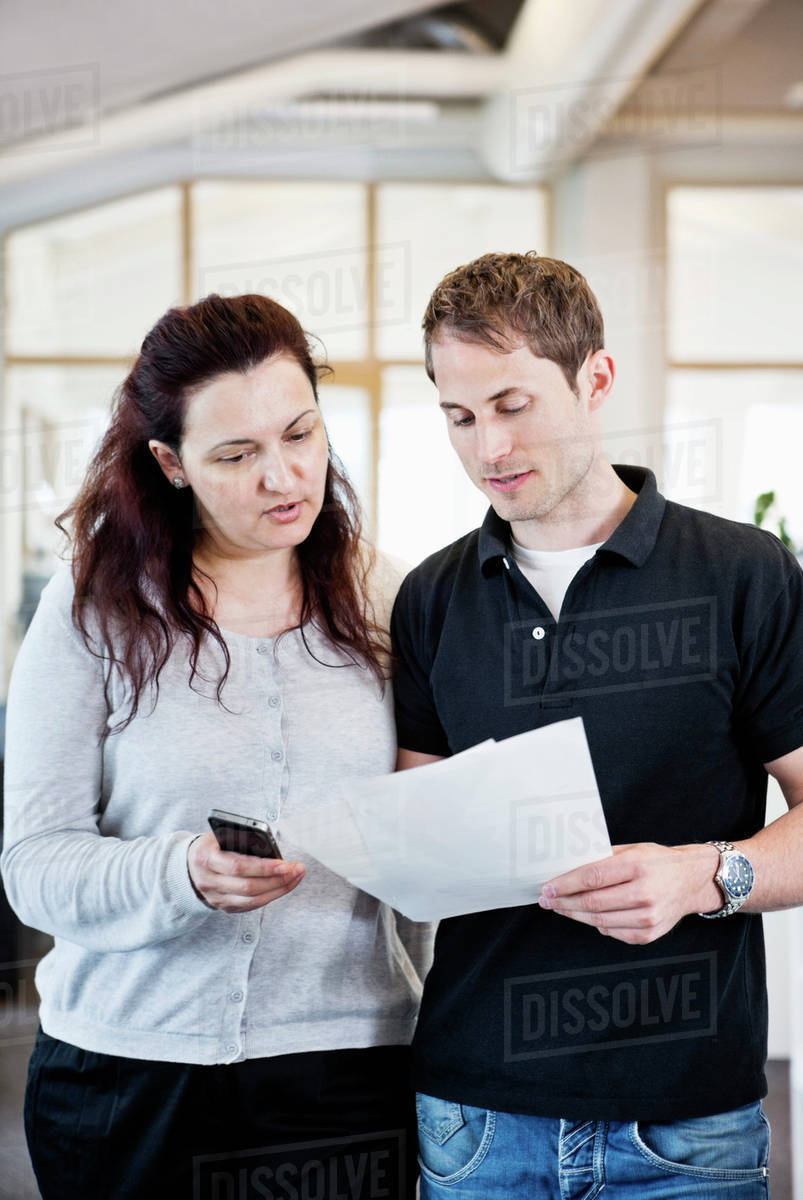 Business executive reading documents - Stock Photo - Dissolve