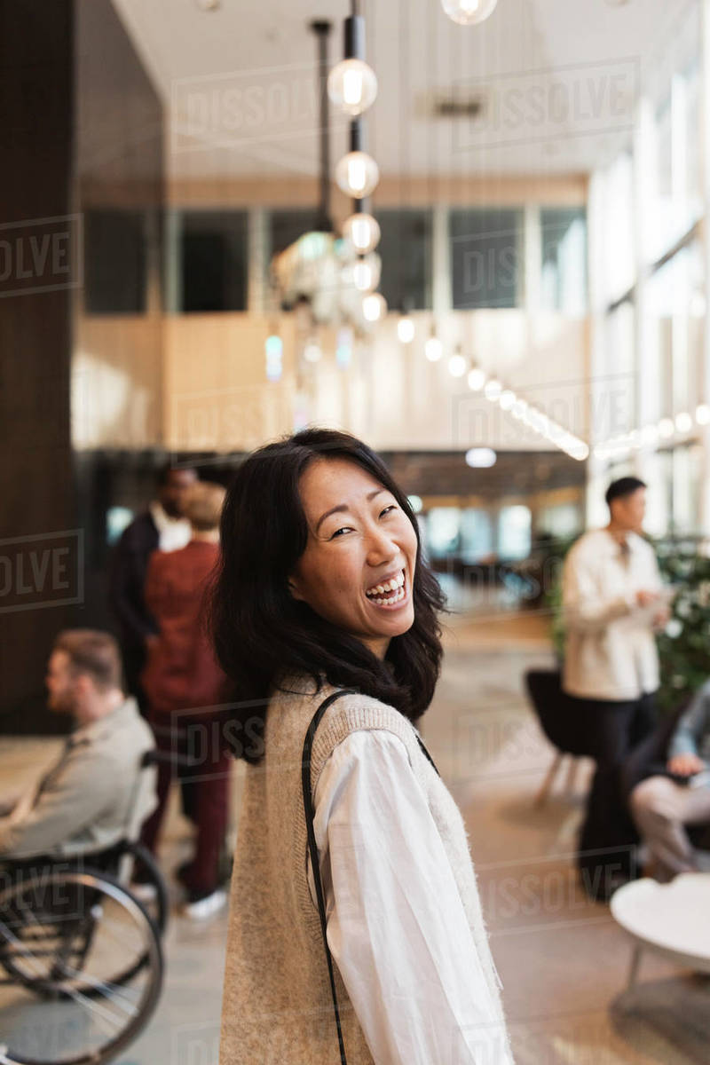 Side view portrait of happy businesswoman laughing while standing in ...