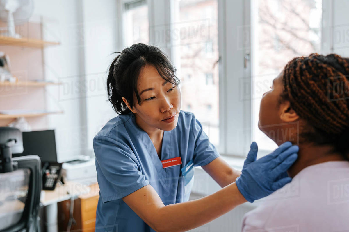 Female medical expert checking lymph nodes of young patient in ...