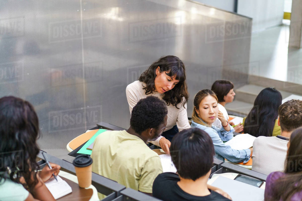 High angle view of teacher explaining to students in classroom at ...
