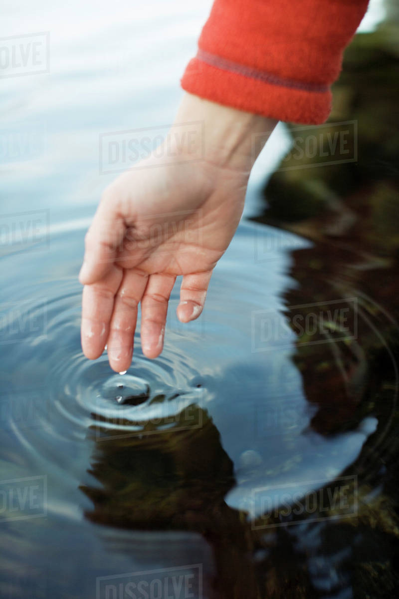 Woman's hand touching water forming ripple - Royalty-free Stock Photo ...