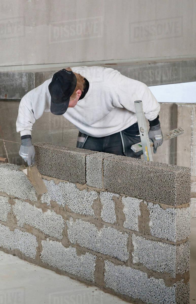 Construction worker applying cement on concrete bricks - Stock Photo ...