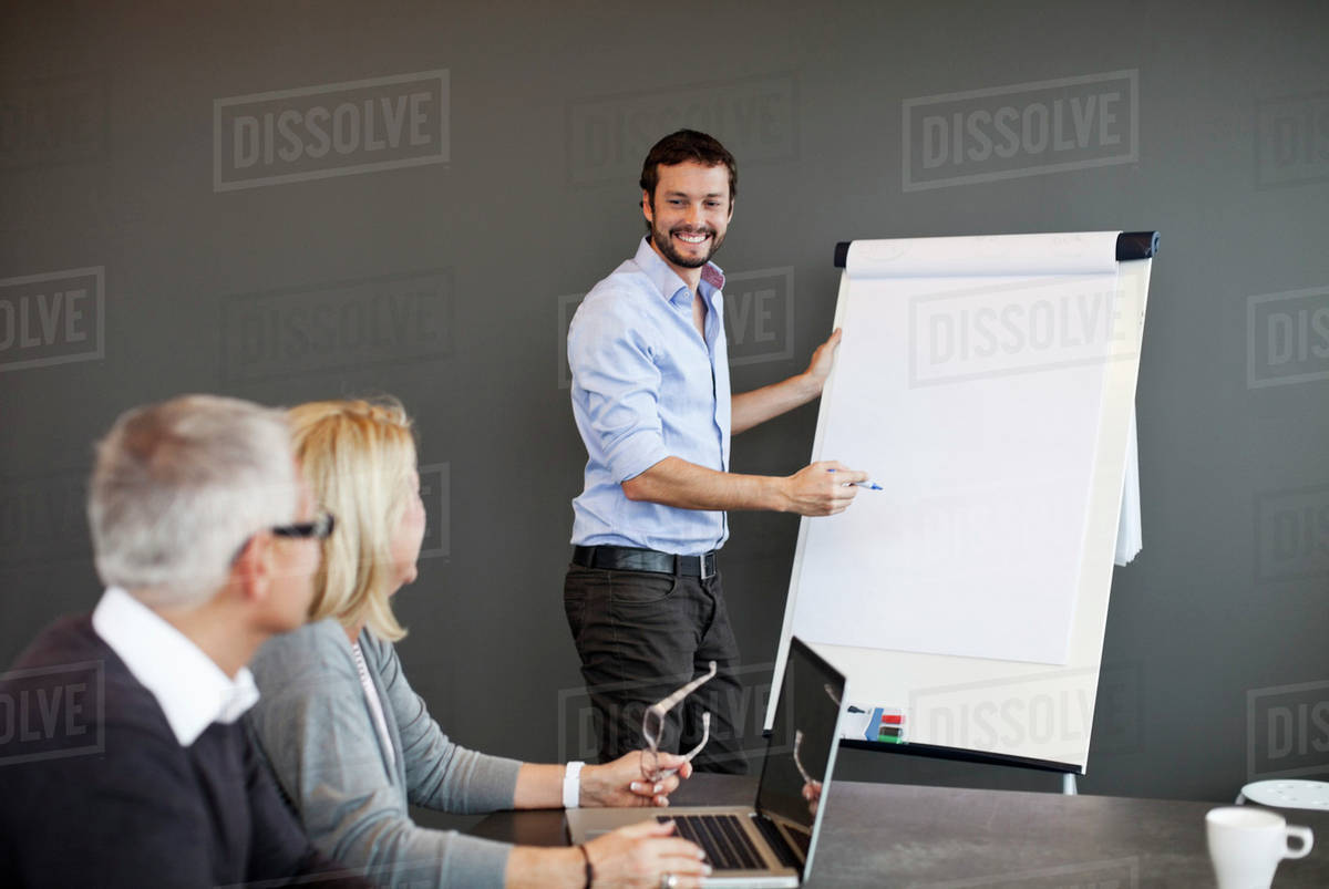 Businessman using whiteboard during meeting with executives - Royalty-free Stock Photo | Dissolve