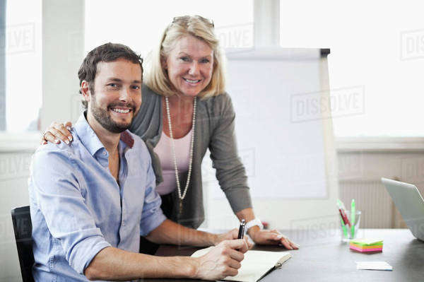 Portrait of two business colleagues smiling in office - Stock Photo ...