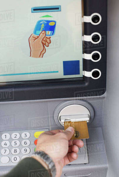 Hand inserting card into ATM - Stock Photo - Dissolve