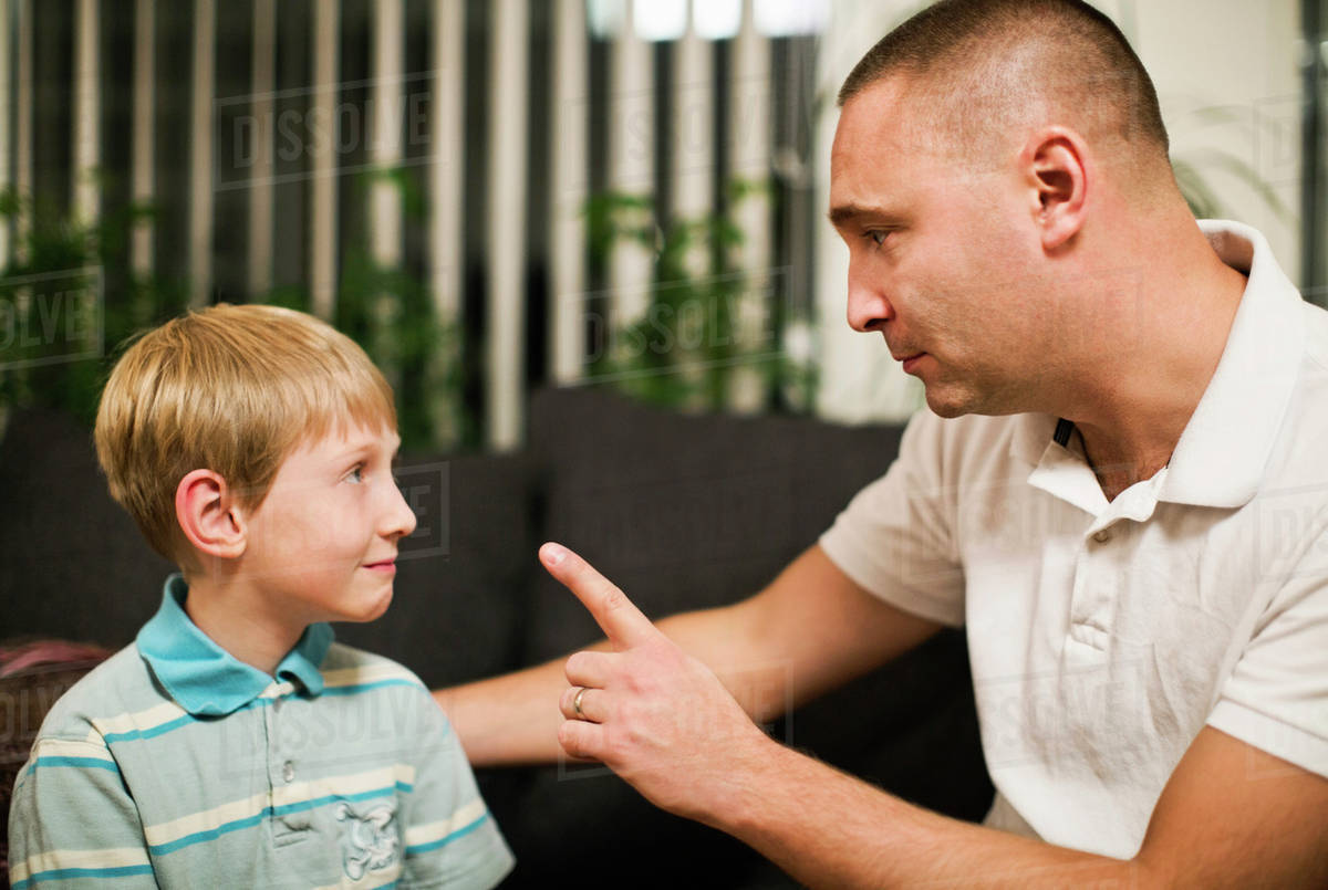 Angry mid adult man disciplining son at home - Royalty-free Stock Photo ...
