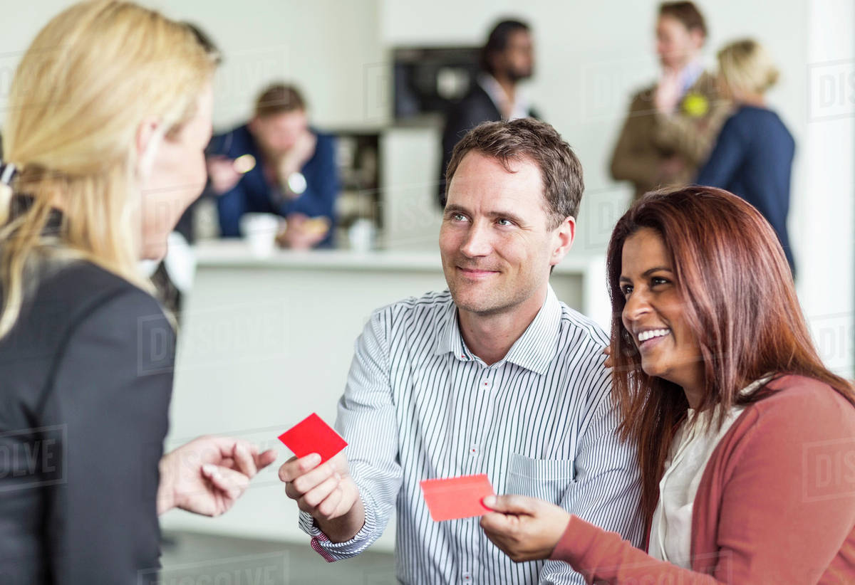 Business people giving business card to woman in office - Stock Photo ...