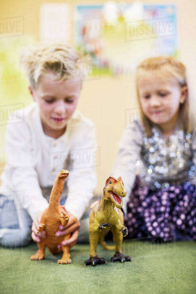 Children playing with toy dinosaurs in kindergarten - Royalty-free ...