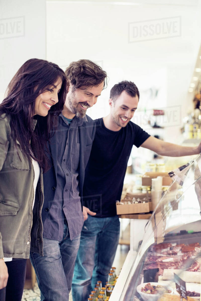 Three friends shopping together in grocery store - Stock Photo - Dissolve