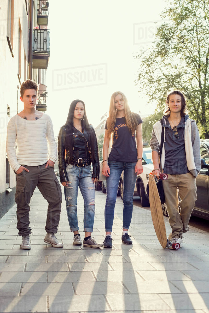 Full length portrait of confident high school students standing on ...