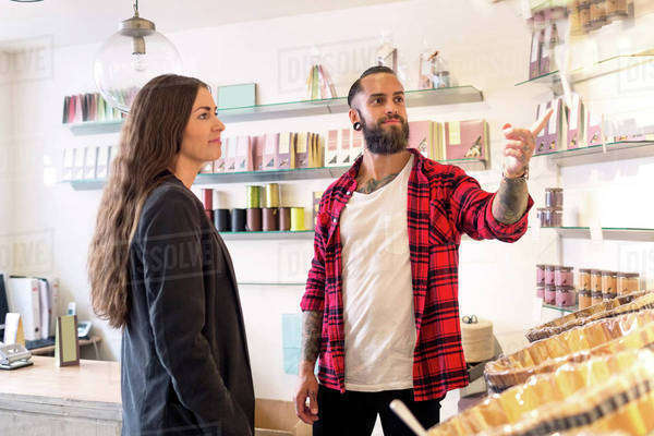 Owner showing products to customer in candy store - Stock Photo - Dissolve
