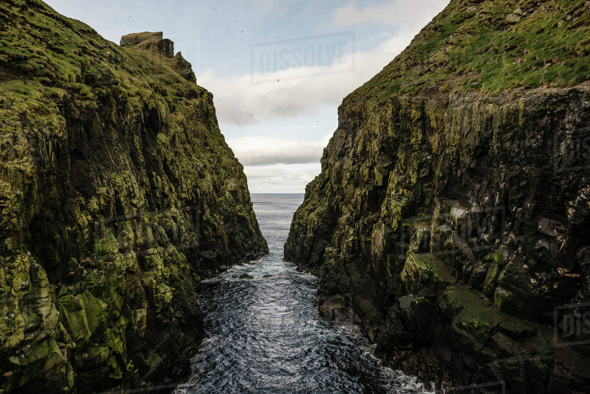 River flowing between huge cliffs at Faroe islands - Stock Photo - Dissolve