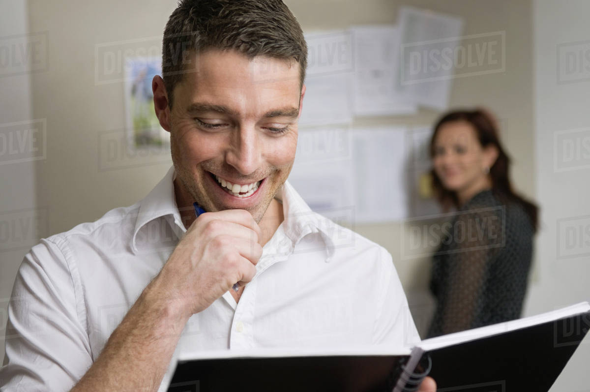 Man looking in notebook - Royalty-free Stock Photo | Dissolve