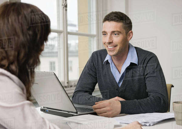 Two people talking at desk - Royalty-free Stock Photo | Dissolve