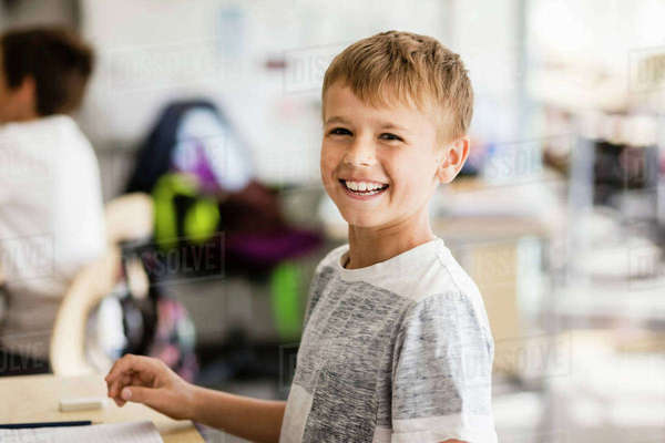 Portrait of happy boy in classroom at school - Royalty-free Stock Photo ...