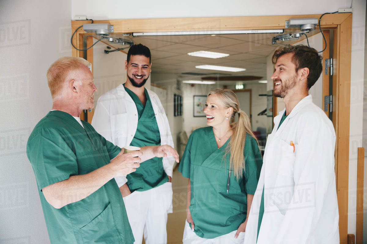 Cheerful medical colleagues talking in hospital corridor - Royalty-free ...