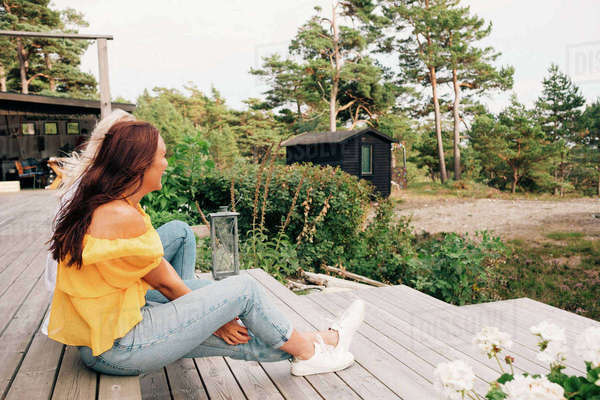 Happy young women sitting on cottage deck - Royalty-free Stock Photo ...