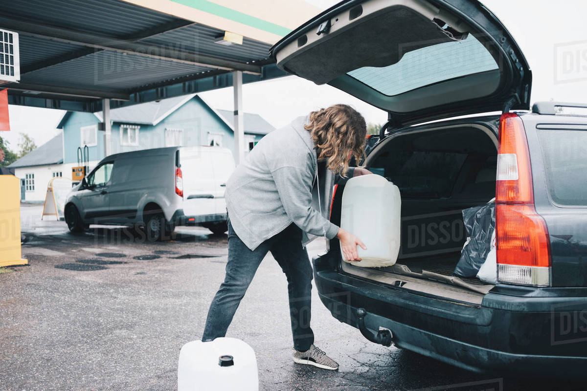 Man keeping containers in car trunk on road - Royalty-free Stock Photo ...