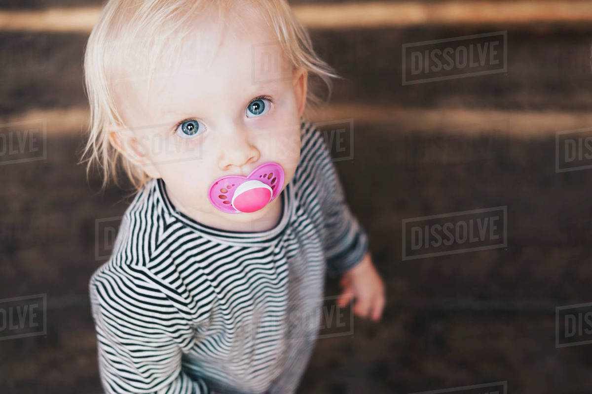 High angle view of girl with pacifier standing outdoors - Royalty-free ...