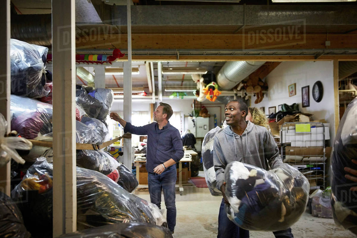 Coworkers stacking plastic sacks in warehouse - Royalty-free Stock ...