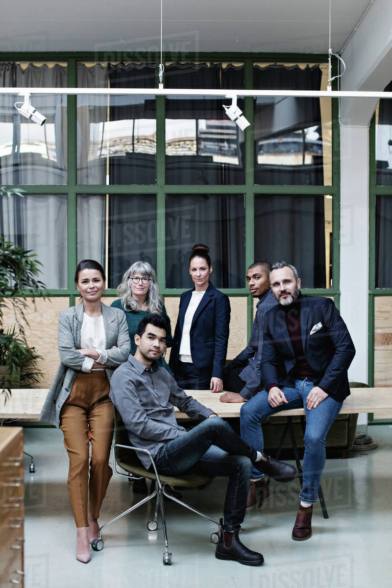 Full length portrait of confident business team at table in creative ...