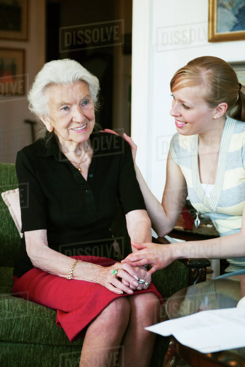 Two women sitting in armchair talking - Royalty-free Stock Photo | Dissolve