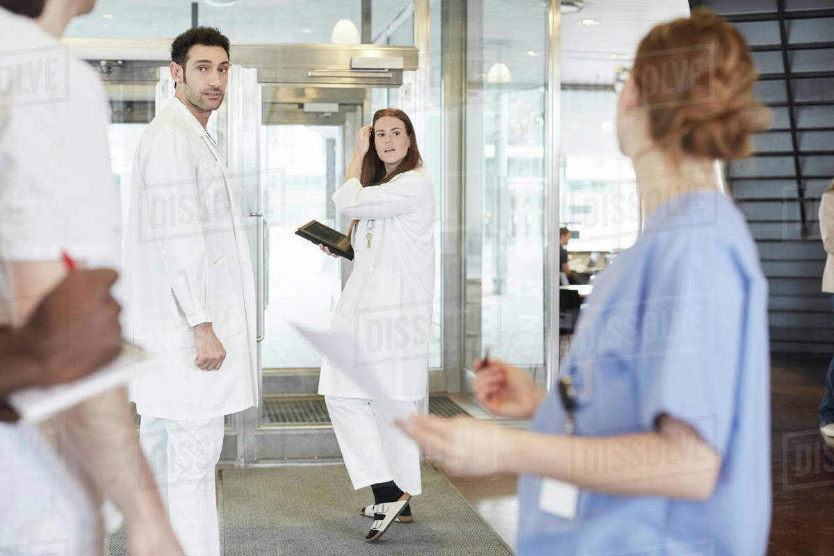 Multi-ethnic healthcare workers discussing at lobby in hospital ...