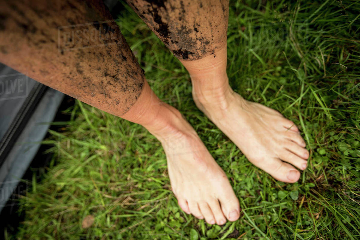 Low section of woman with dirty legs on field - Stock Photo - Dissolve