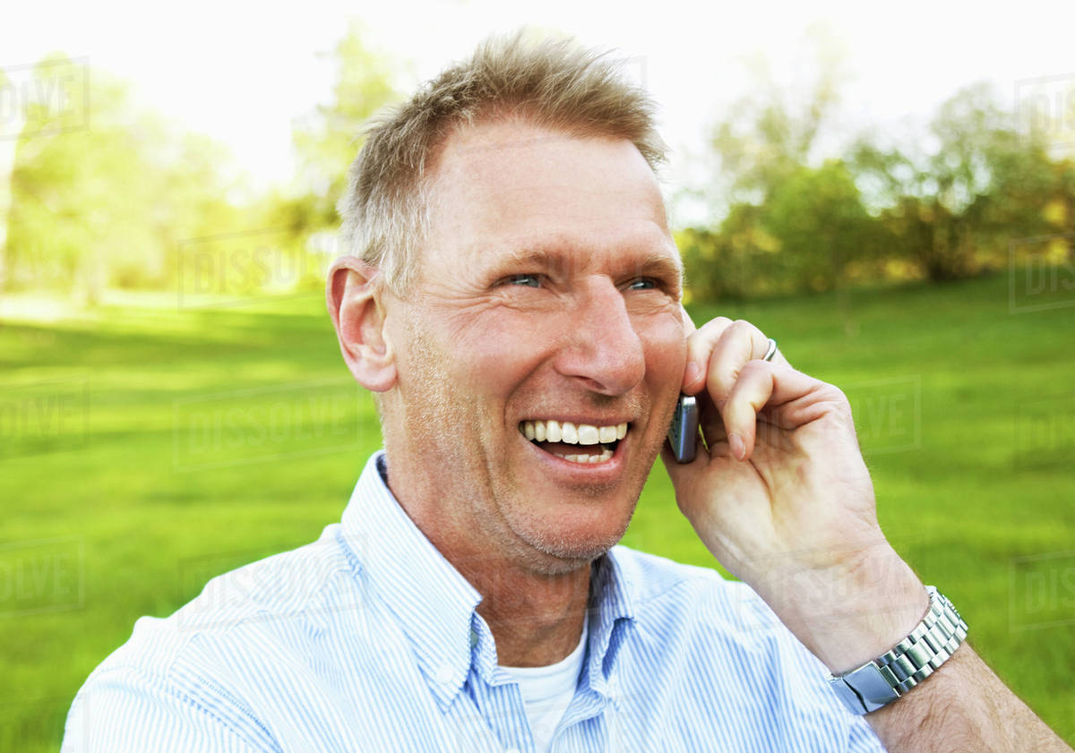 Laughing man talking in phone - Stock Photo - Dissolve