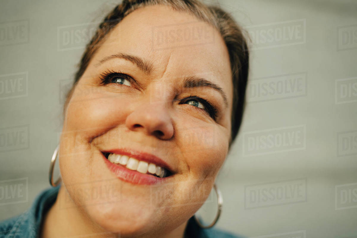 Close-up of smiling mature woman against wall - Royalty-free Stock ...
