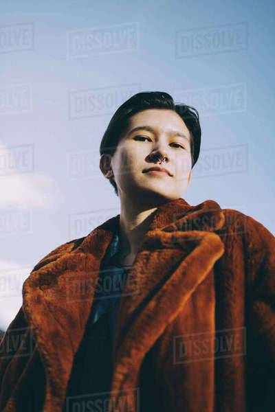 Low angle portrait of woman against sky - Stock Photo - Dissolve