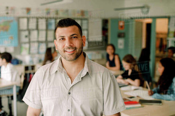 Portrait of smiling male teacher standing in classroom - Royalty-free ...
