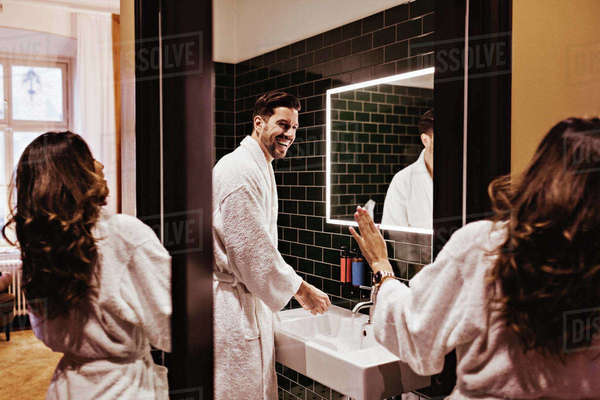 Woman at entrance of bathroom while smiling man standing in front of ...
