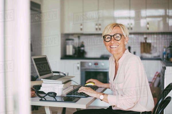 Portrait of happy woman working at home - Stock Photo - Dissolve