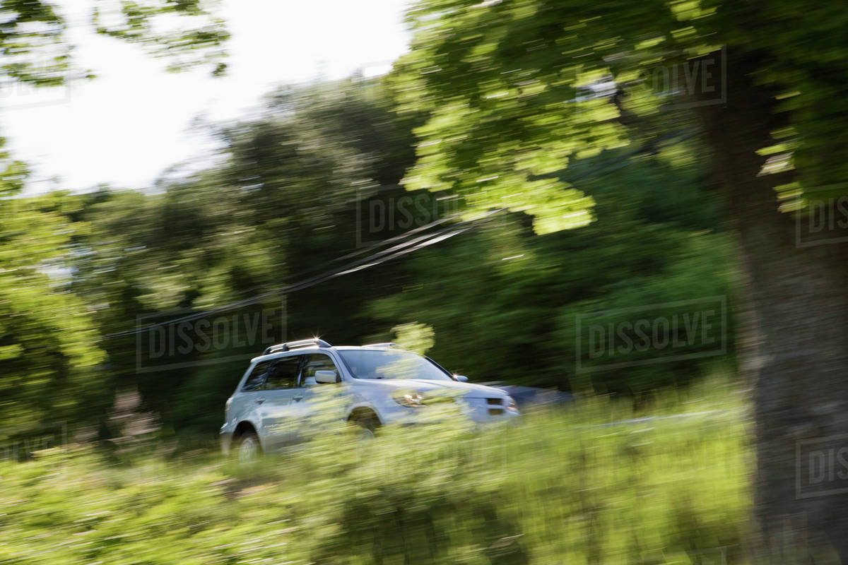Car driving in forest - Stock Photo - Dissolve