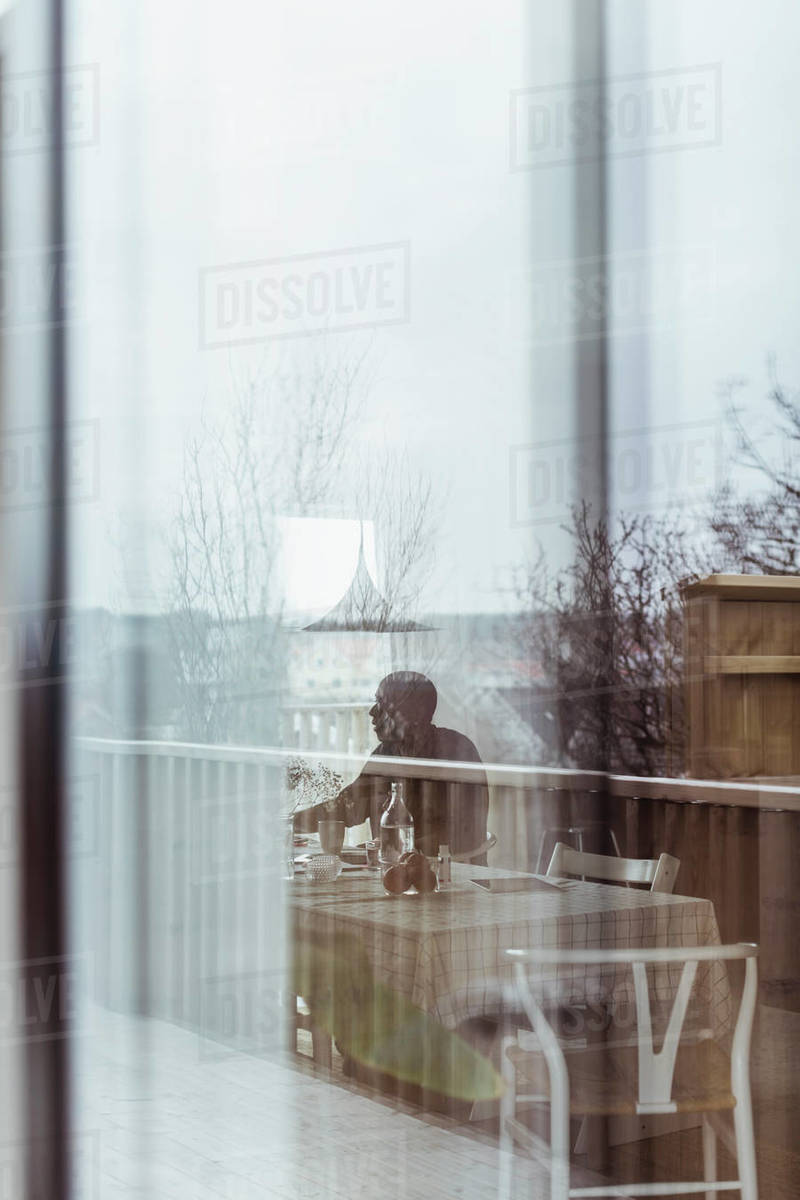 Hispanic man seen through glass window of home - Royalty-free Stock ...
