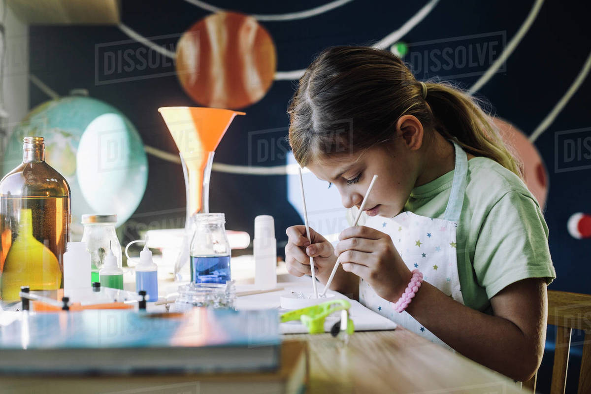 Ambitious female student learning scientific experiment at home ...