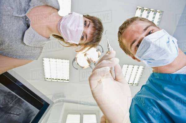 Dentist with dental tools and assistant - Royalty-free Stock Photo ...