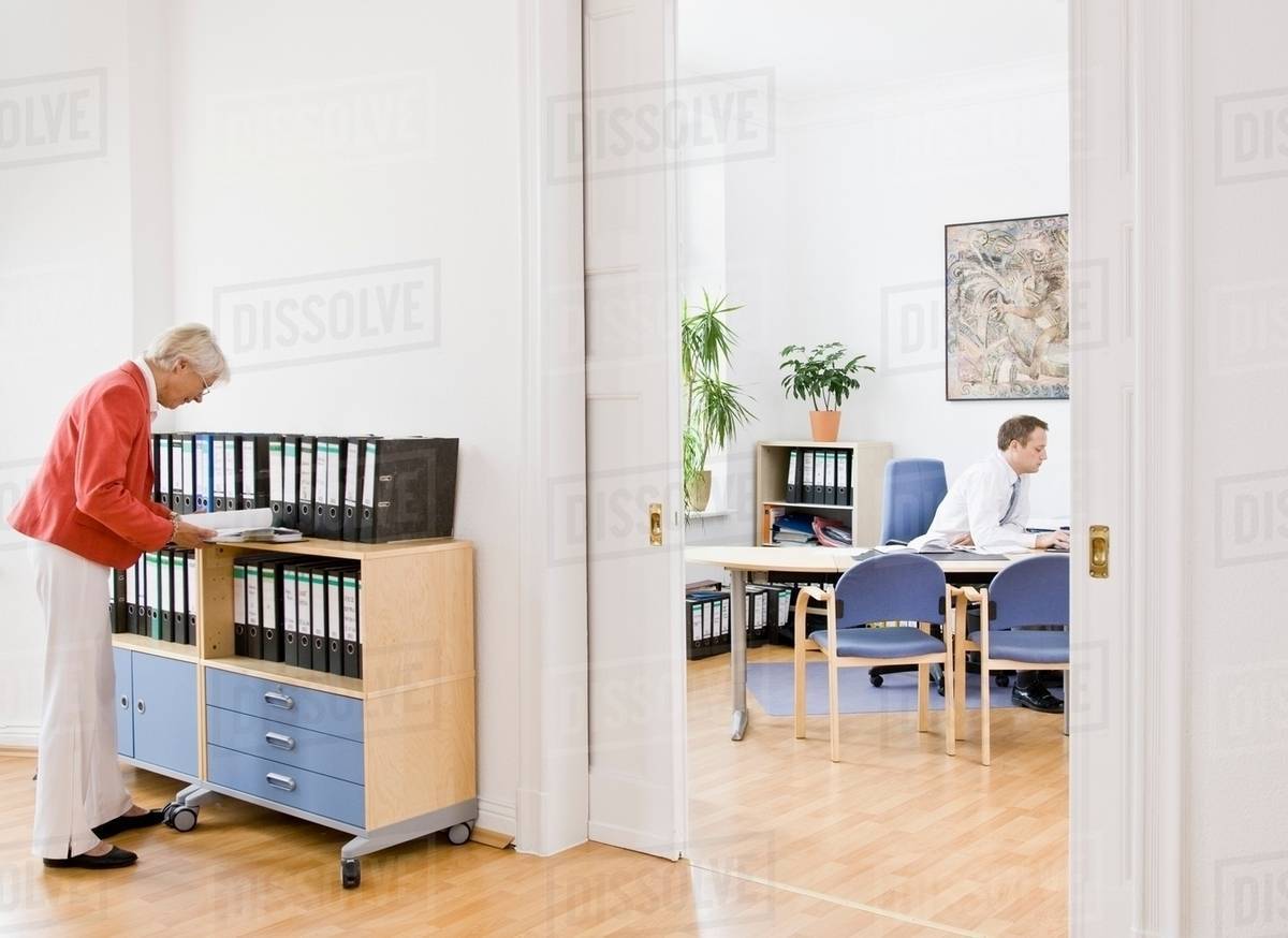 Woman looking through files - Stock Photo - Dissolve