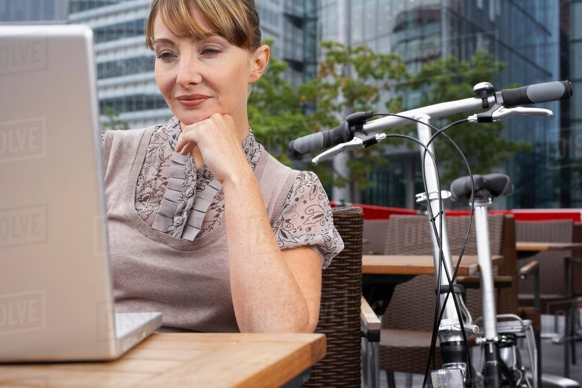 Business woman using laptop outside - Stock Photo - Dissolve