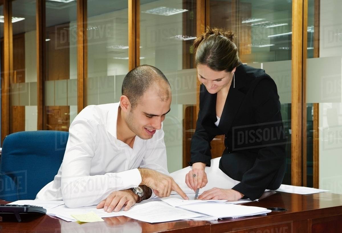 Two young adults working together - Royalty-free Stock Photo | Dissolve
