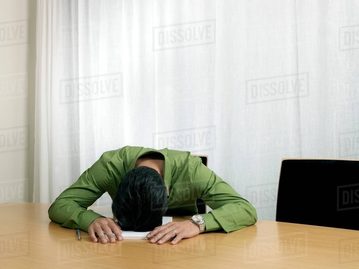 Business man by desk, head on table - Royalty-free Stock Photo | Dissolve
