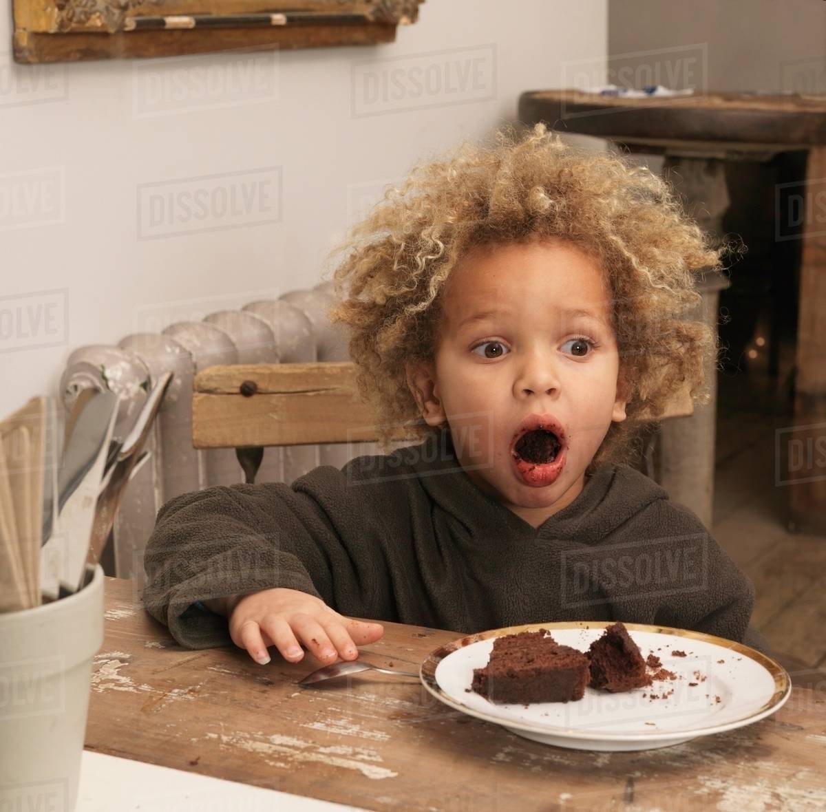 Young boy eating chocolate cake - Stock Photo - Dissolve